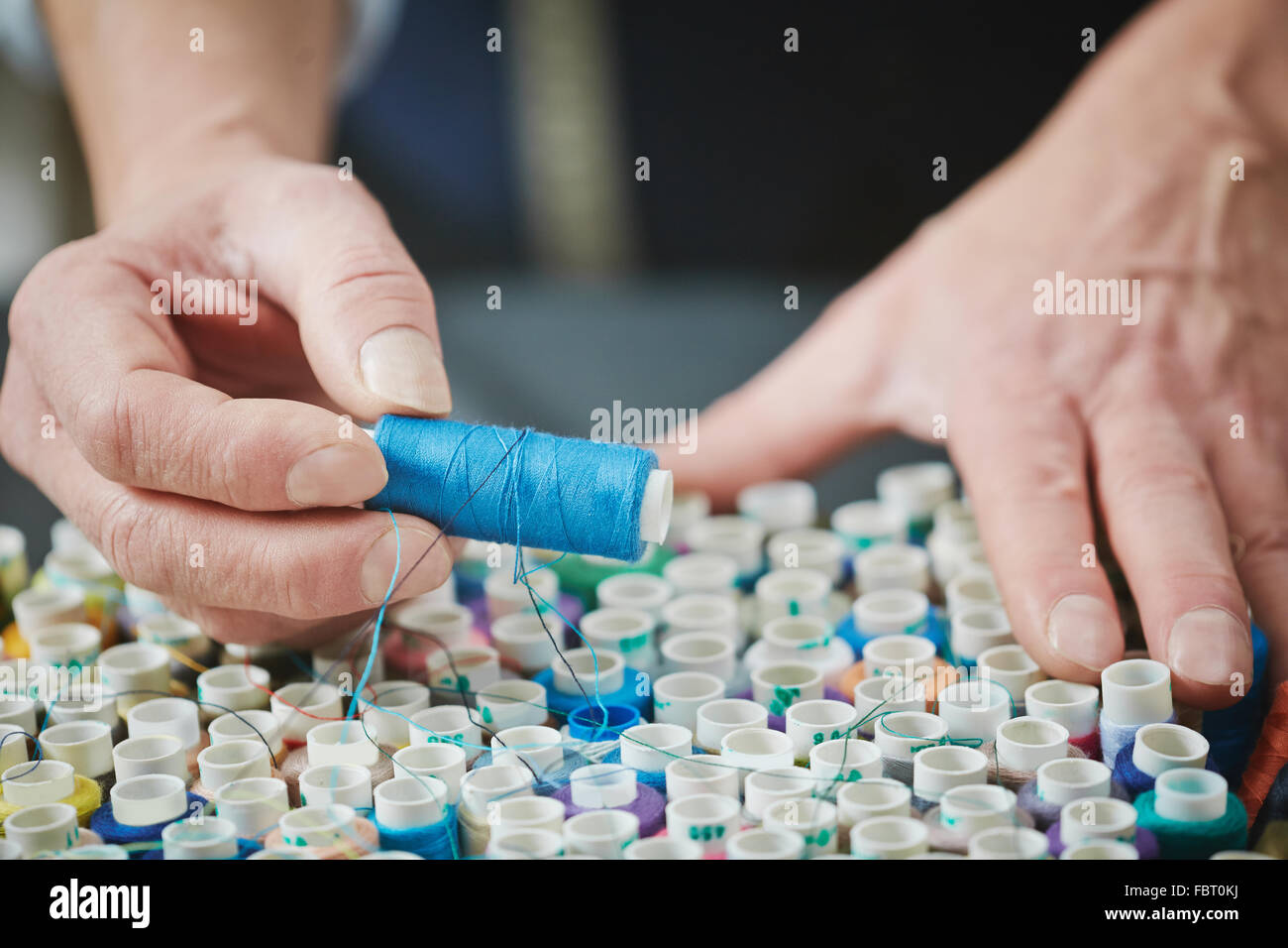 Tailor choosing threads for sewing clothes Stock Photo - Alamy