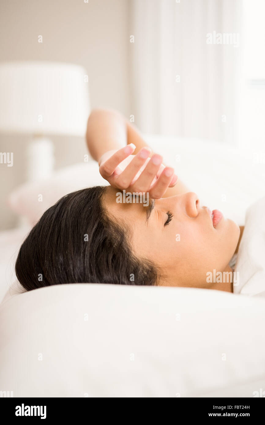 Frowning brunette in bed Stock Photo - Alamy
