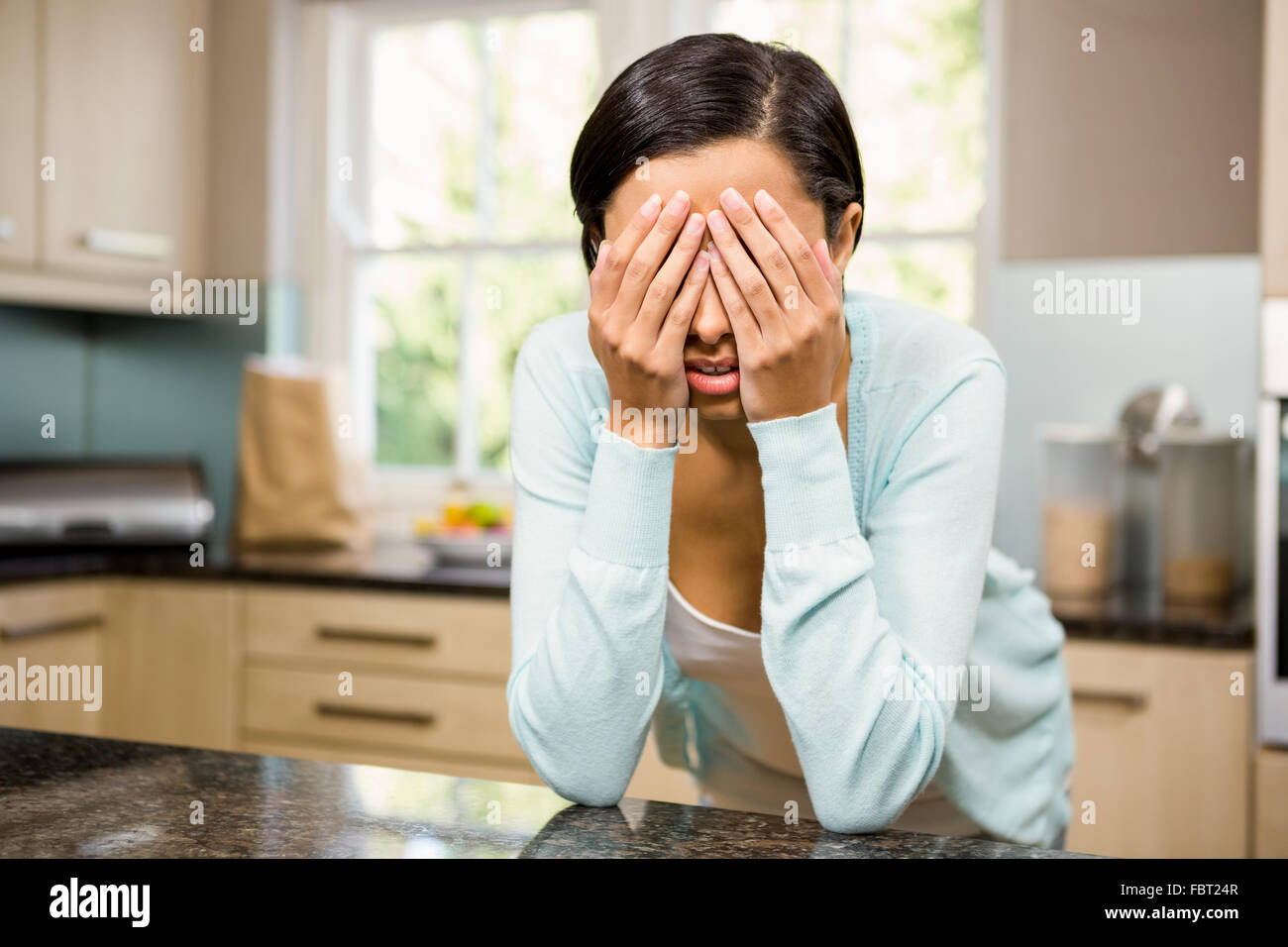 Sad brunette with hands on her face Stock Photo - Alamy