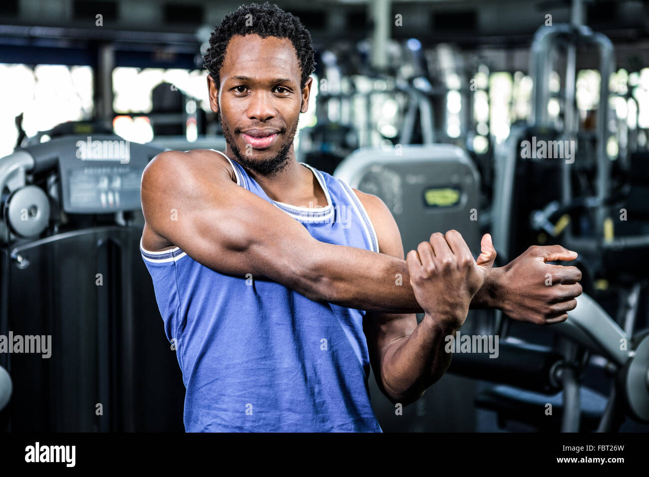 Smiling muscular man stretching arms Stock Photo - Alamy