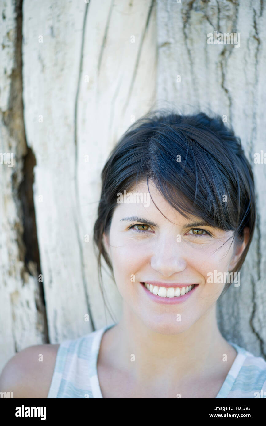 Woman Leaning Against Tree Trunk Smiling Cheerfully Portrait Stock
