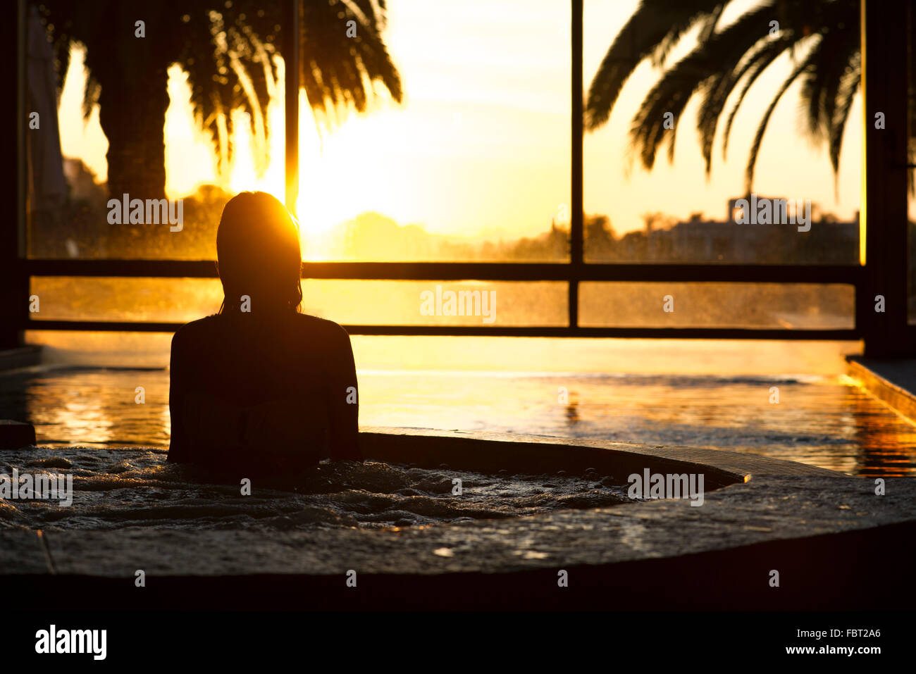Woman in indoor pool during sunset Stock Photo - Alamy