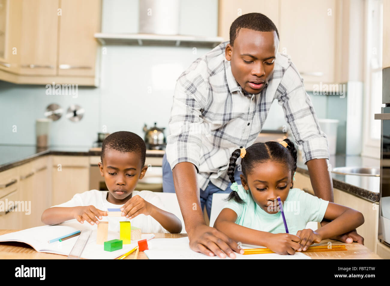 Father helping children for homework Stock Photo - Alamy