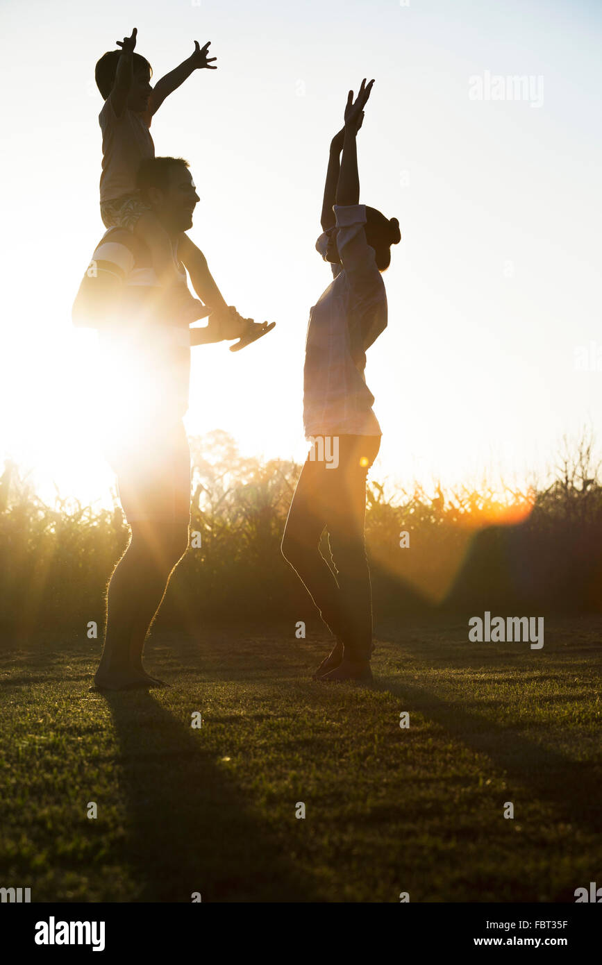 Family spending time outdoors together, father carrying little boy on ...