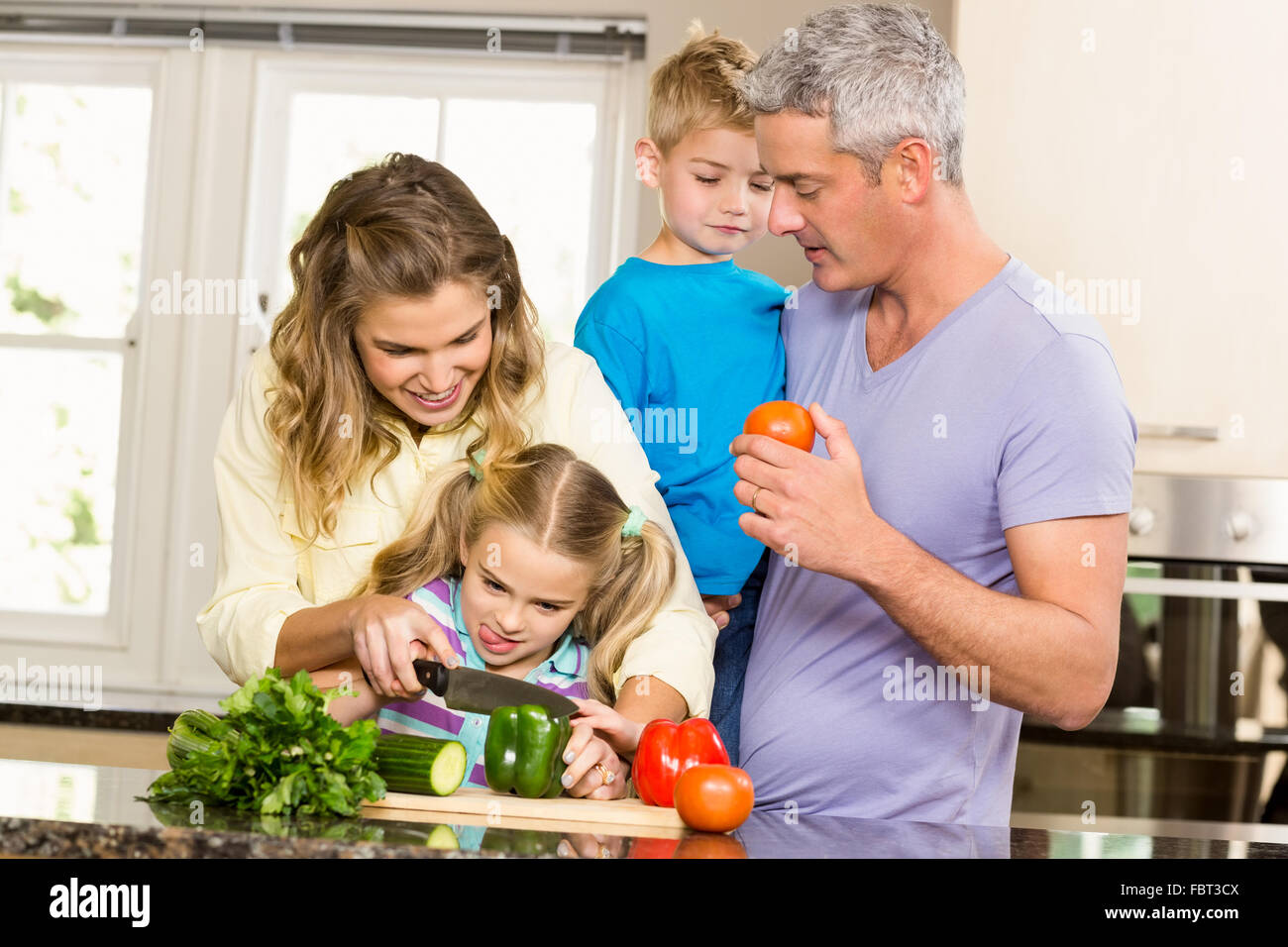 Happy family slicing vegetables Stock Photo - Alamy