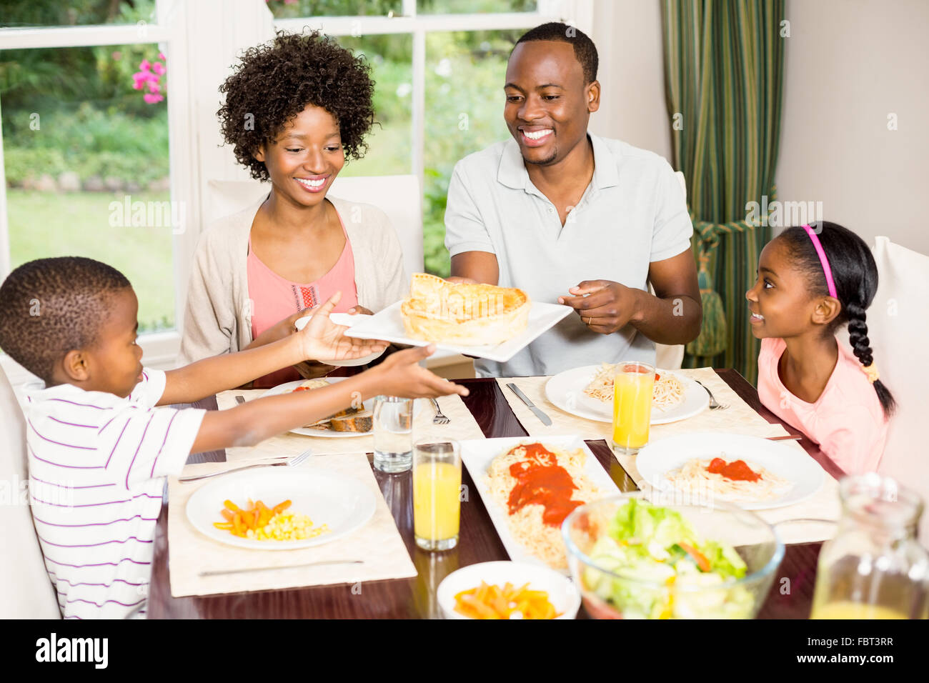 Happy family eating together Stock Photo - Alamy