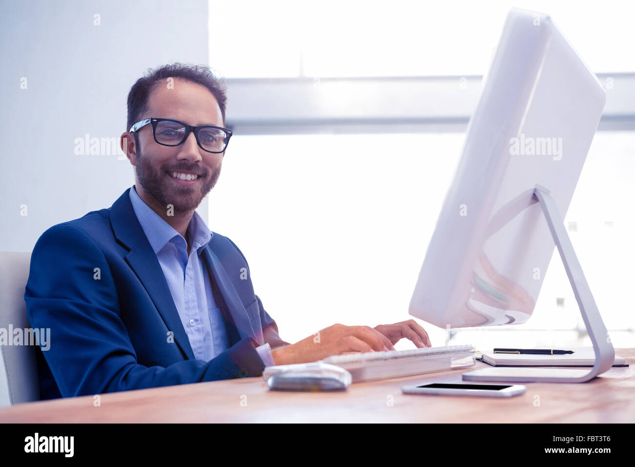 Portrait of happy businessman working on computer in office Stock Photo ...