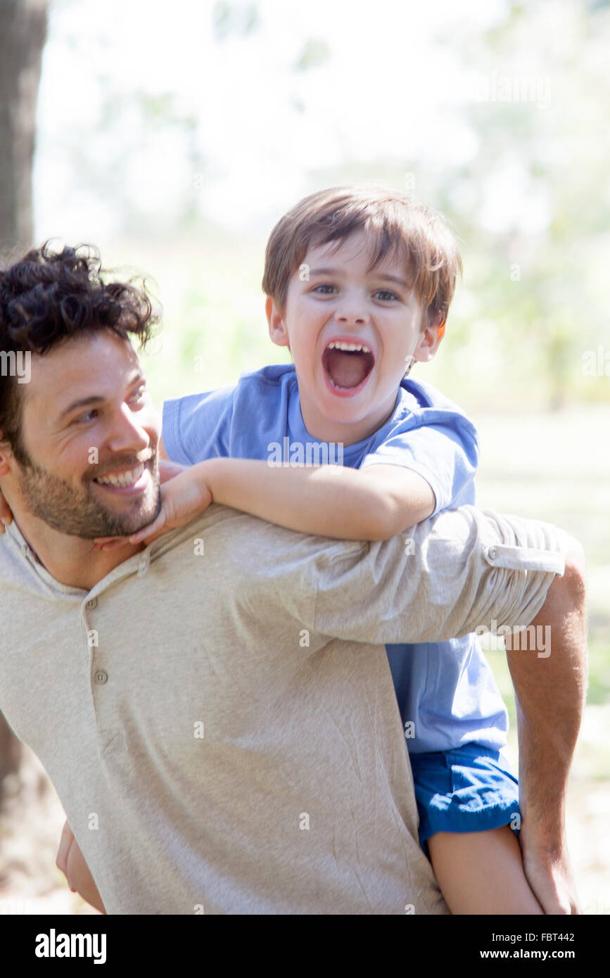 Father giving little boy piggyback ride Stock Photo - Alamy