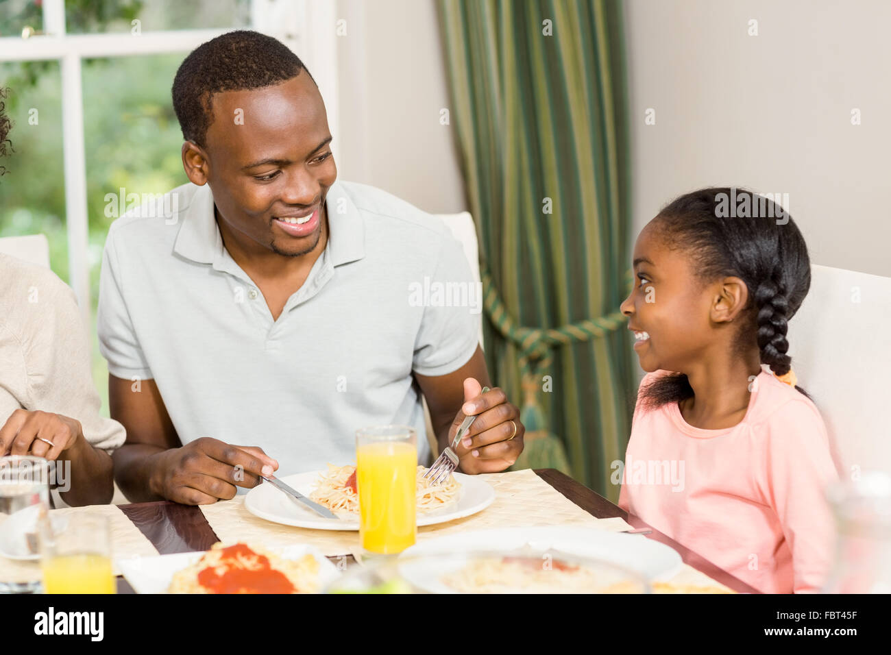 Happy family enjoying their meal Stock Photo - Alamy
