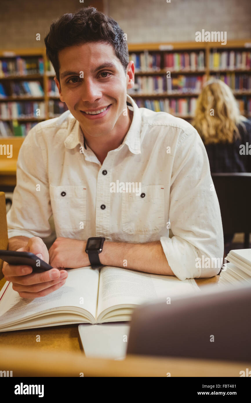 Smiling student using his smartphone Stock Photo - Alamy