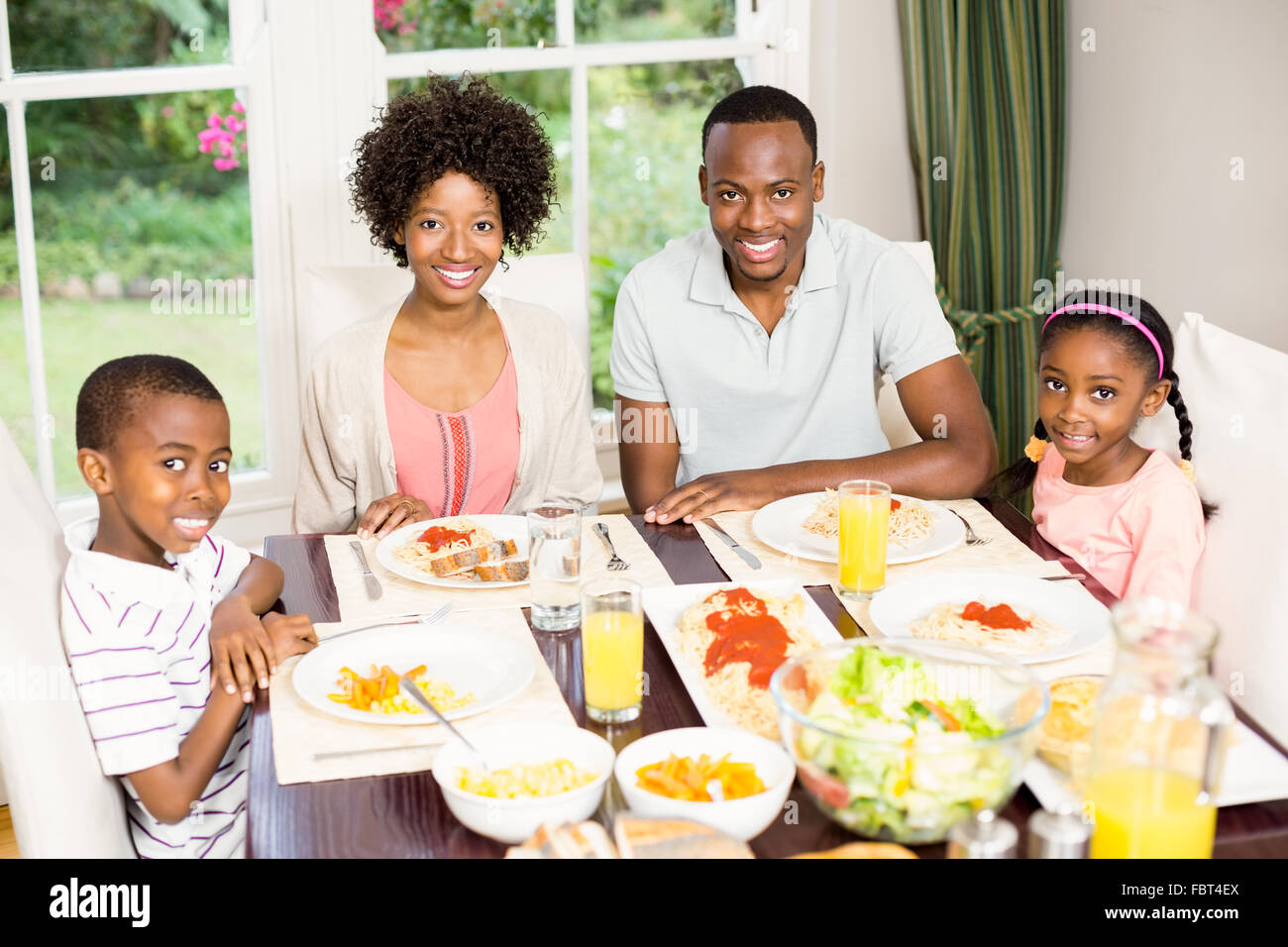 Happy family eating together Stock Photo - Alamy