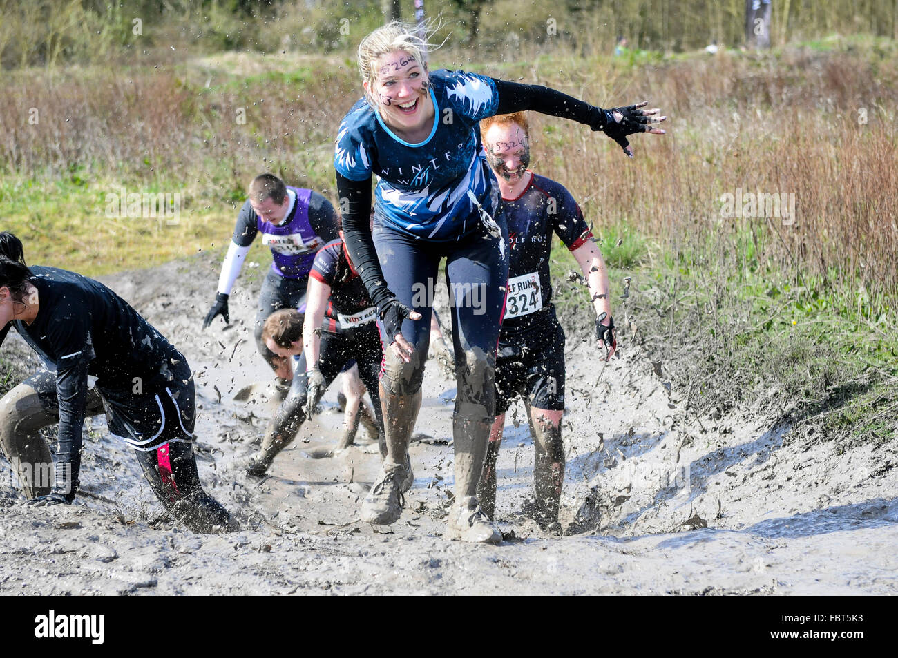 Female runner stuck in mud at obstacle course race, UK Stock Photo - Alamy