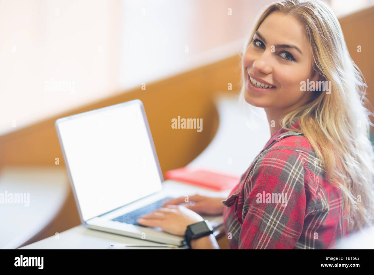 Smiling female student using laptop Stock Photo - Alamy