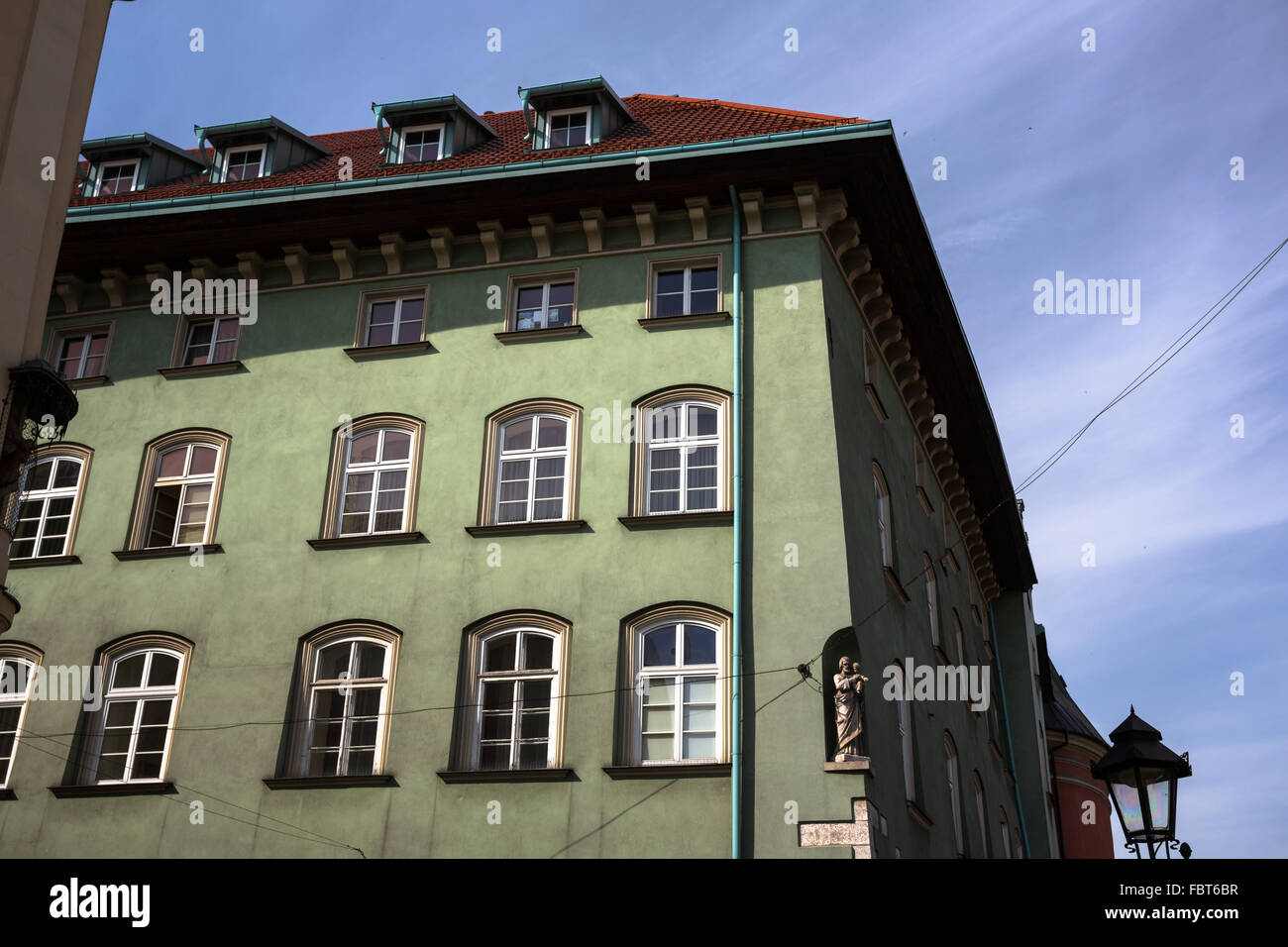 Green building against blue sky with light clouds - Krakow, Poland ...