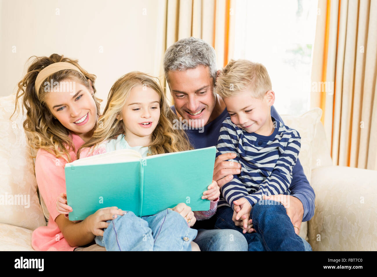 Happy parents reading to their kids Stock Photo - Alamy