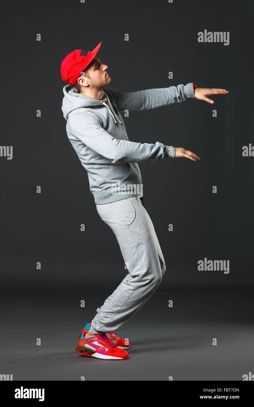 Fullbody portrait of young cool man dancing on dark gray background ...
