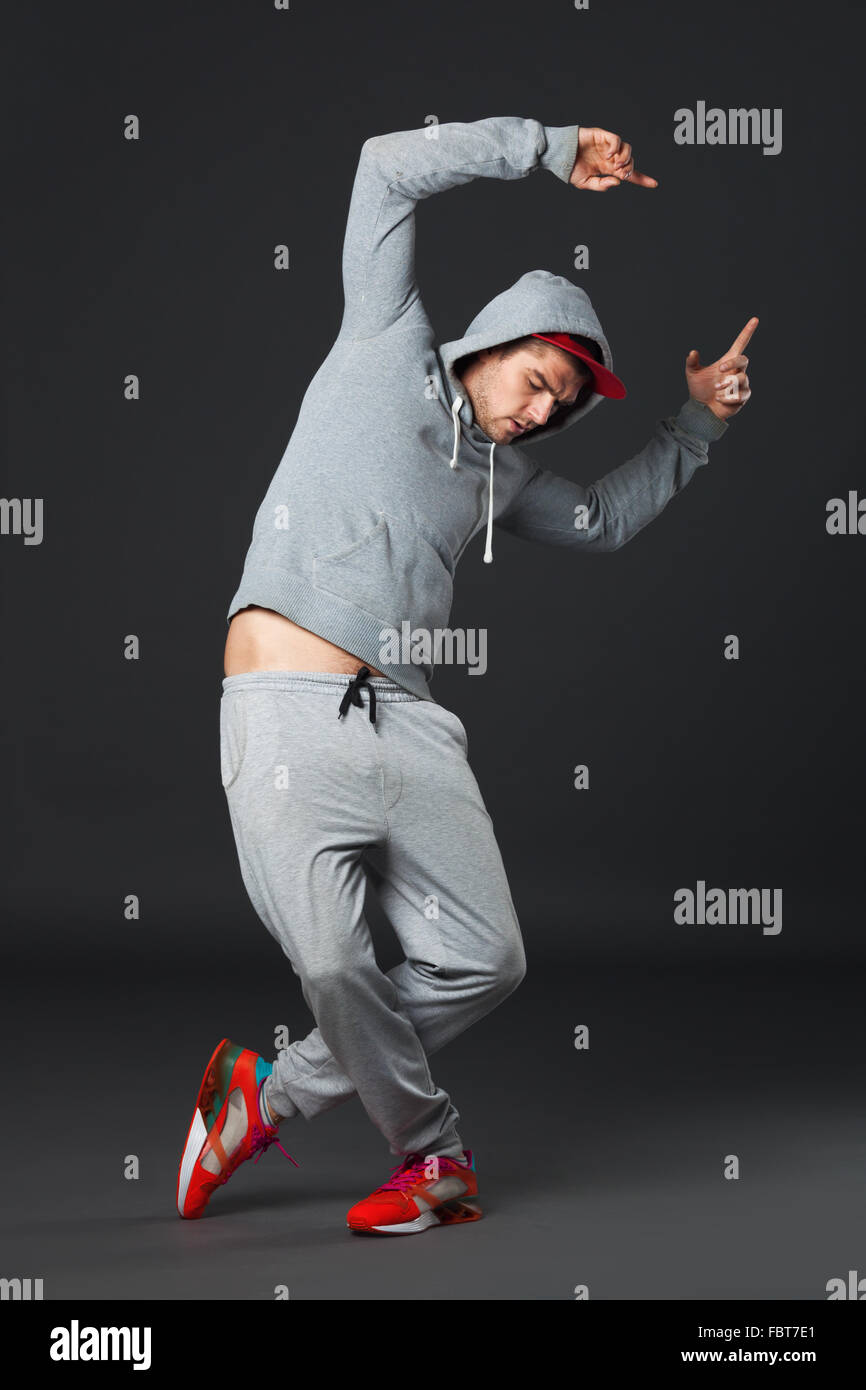 Fullbody portrait of young cool man dancing on dark gray background ...
