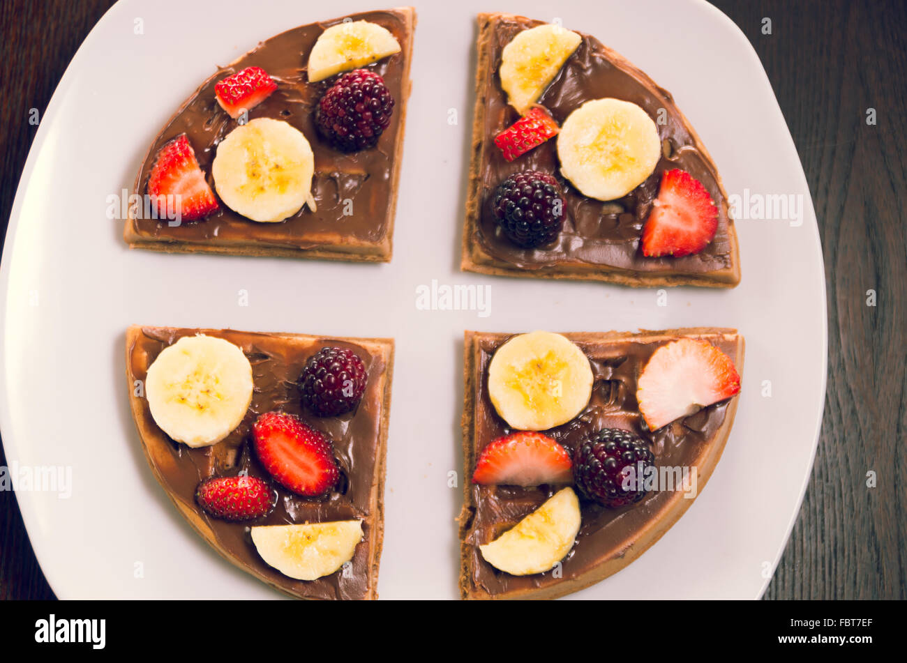 Pancake cut in four parts decorated with fruits, glass of orange juice ...
