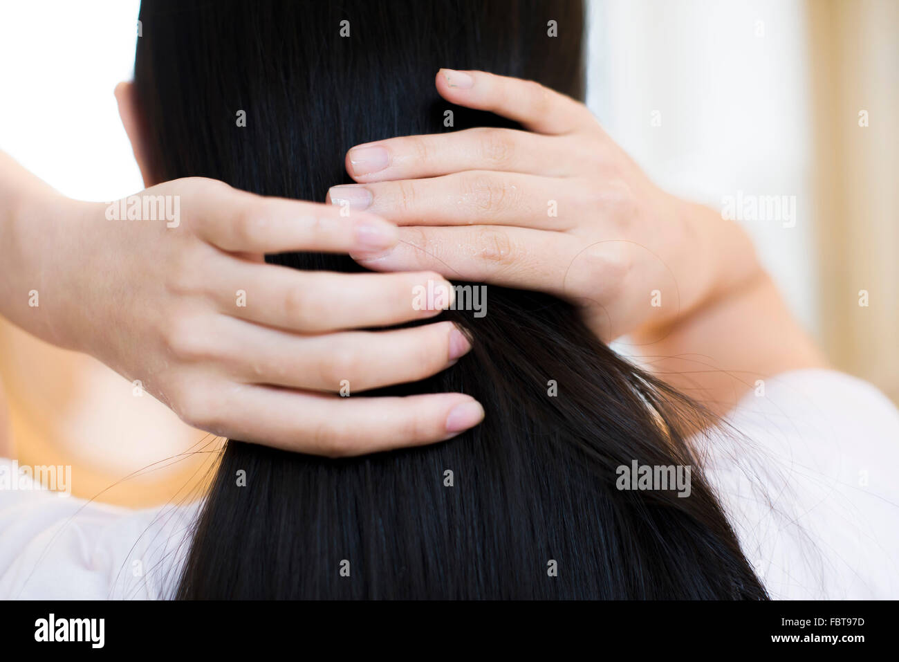 Woman fixing her hair, rear view Stock Photo - Alamy