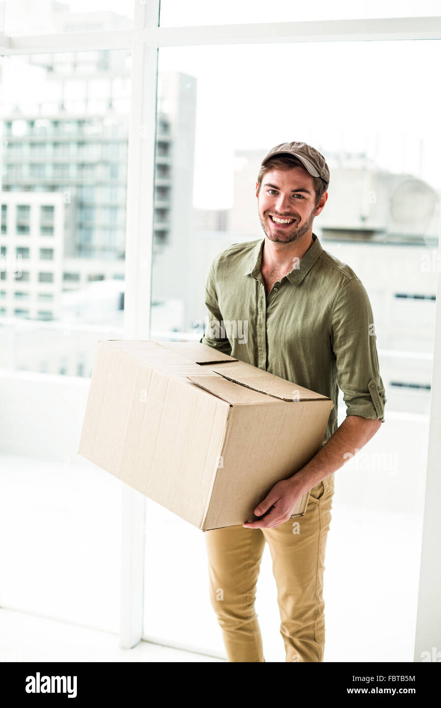 Smiling postman holding package Stock Photo - Alamy