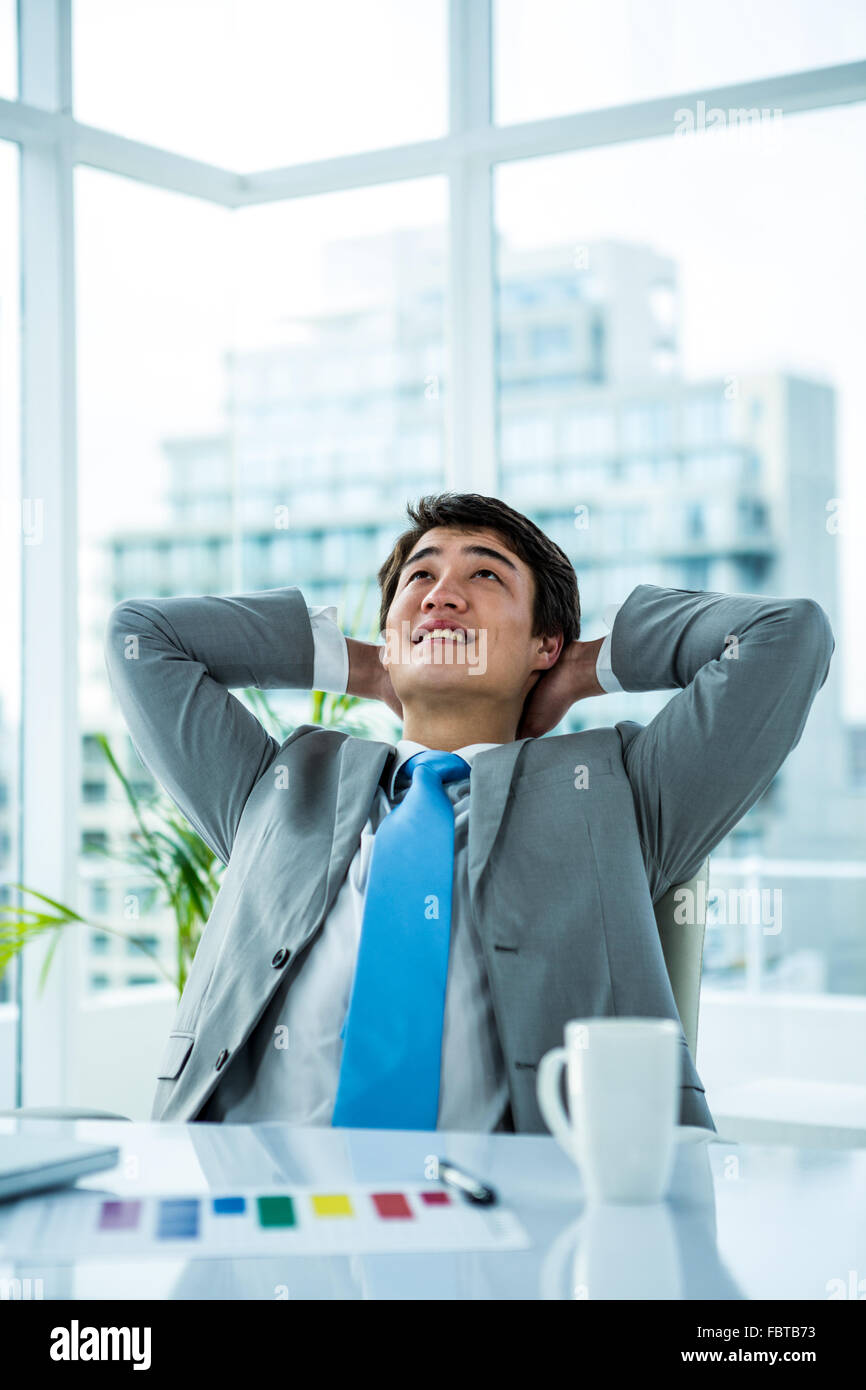 Relaxing asian businessman at his desk Stock Photo - Alamy