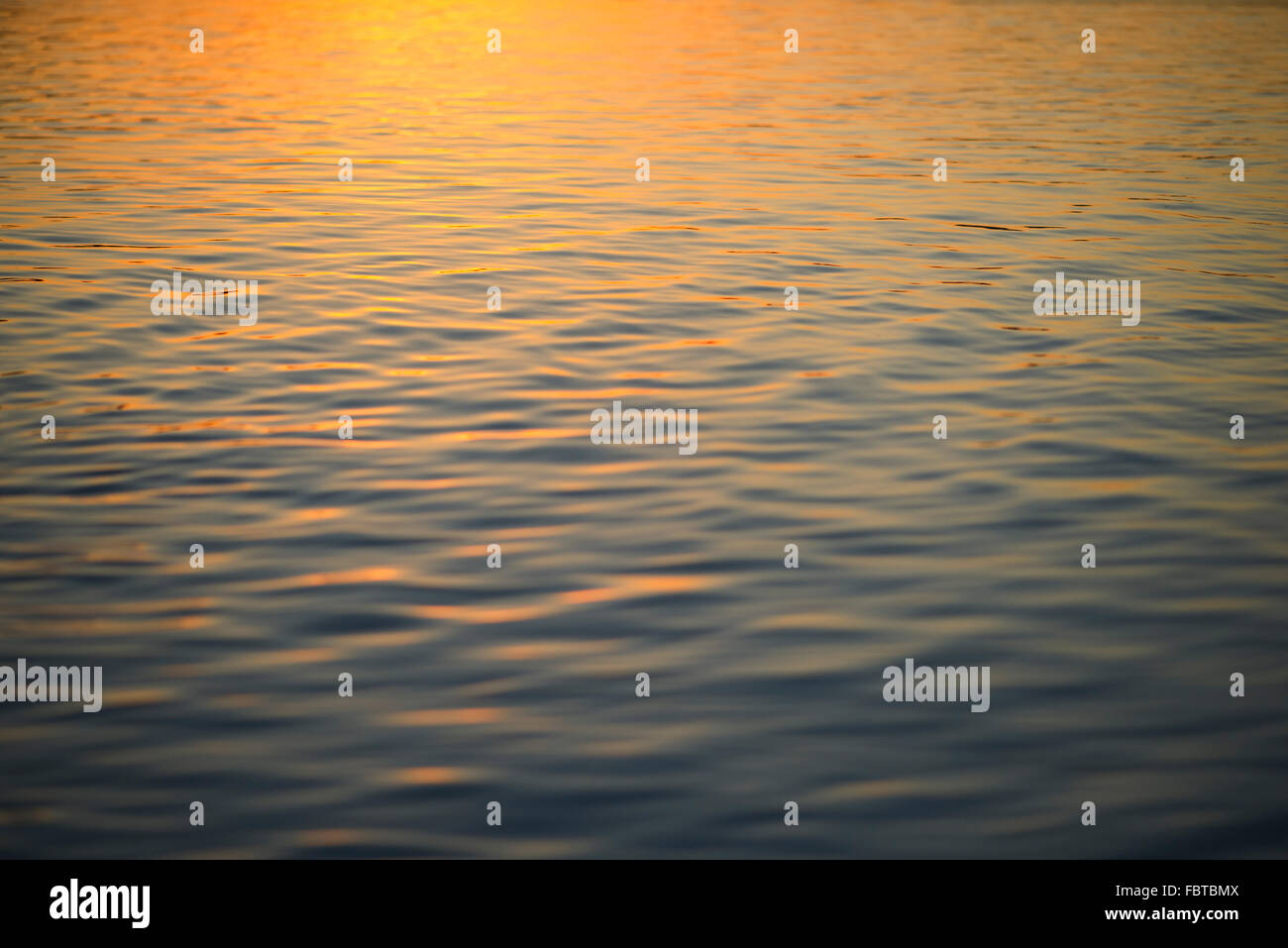 Sunset reflected on surface of water Stock Photo - Alamy