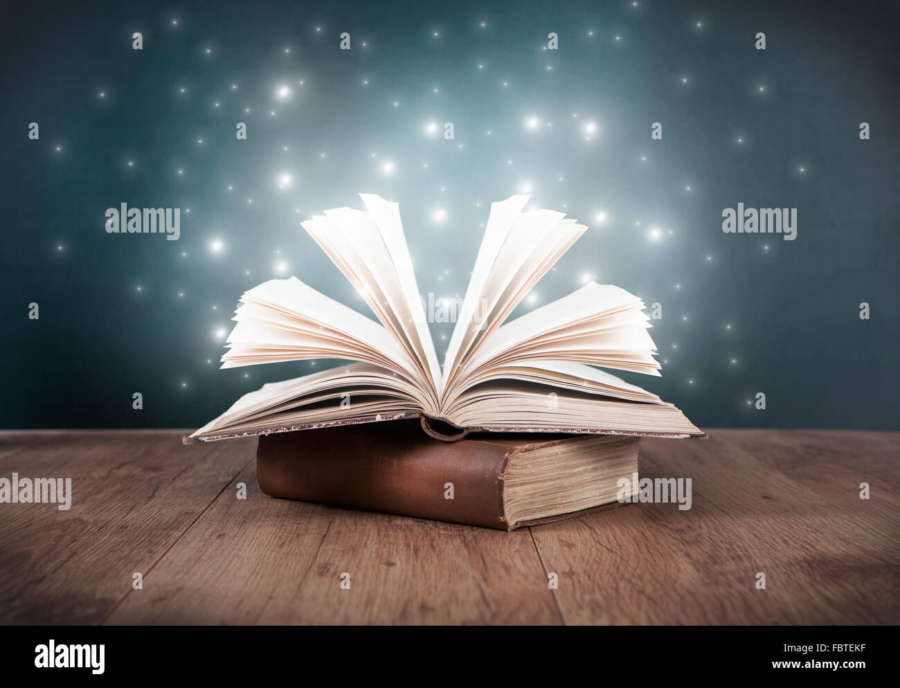 an old open book on a table in front of a blackboard Stock Photo - Alamy
