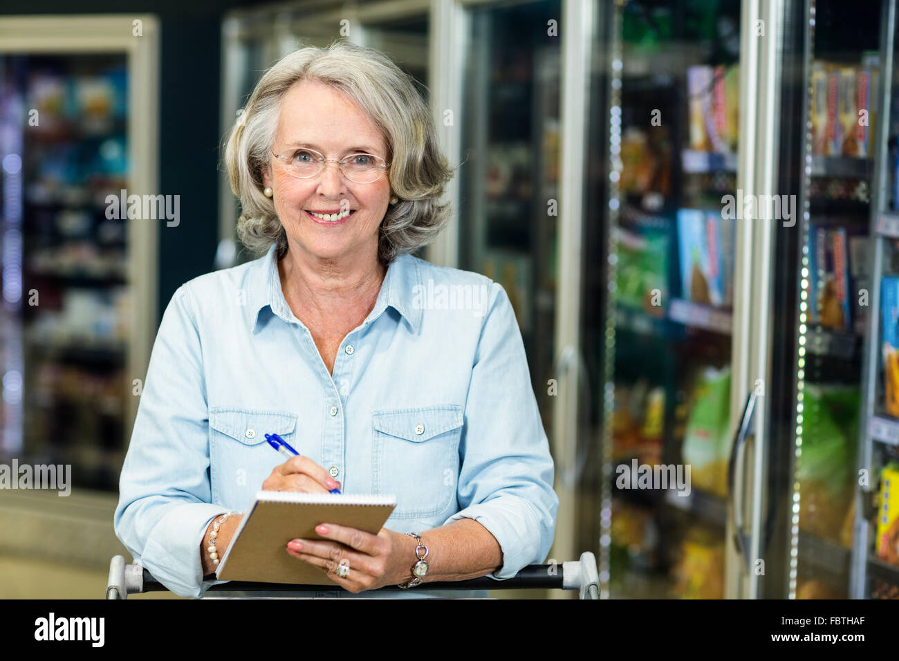 Smiling senior woman holding list Stock Photo - Alamy