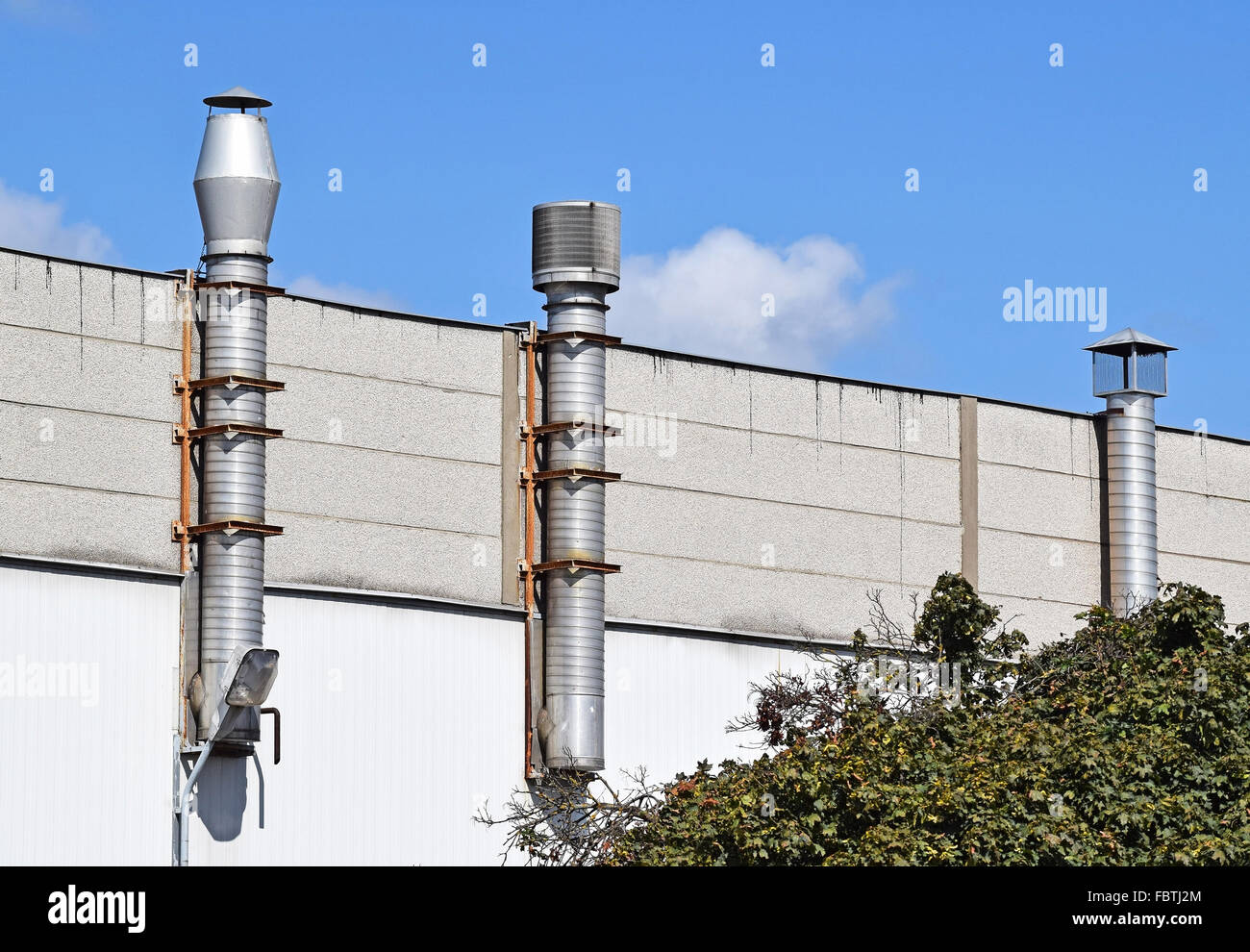 Metal smoke stacks of a factory building Stock Photo - Alamy