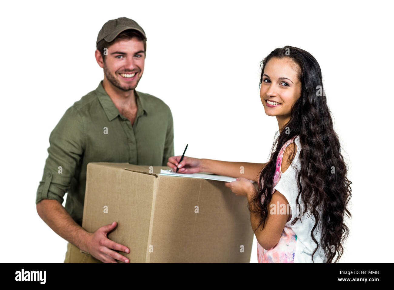 Woman signing for pack delivery with smiling postman Stock Photo - Alamy