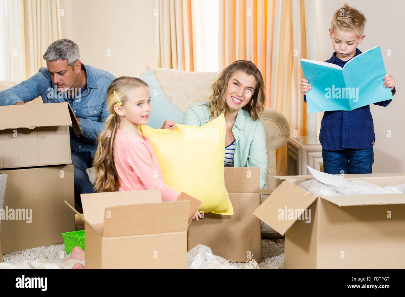 Cute family opening boxes Stock Photo - Alamy