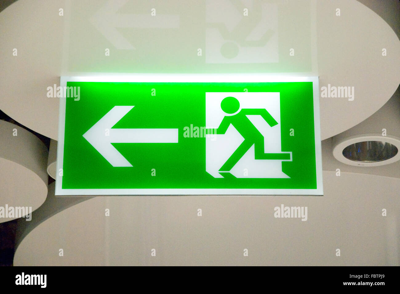 green emergency exit sign in a station Stock Photo - Alamy