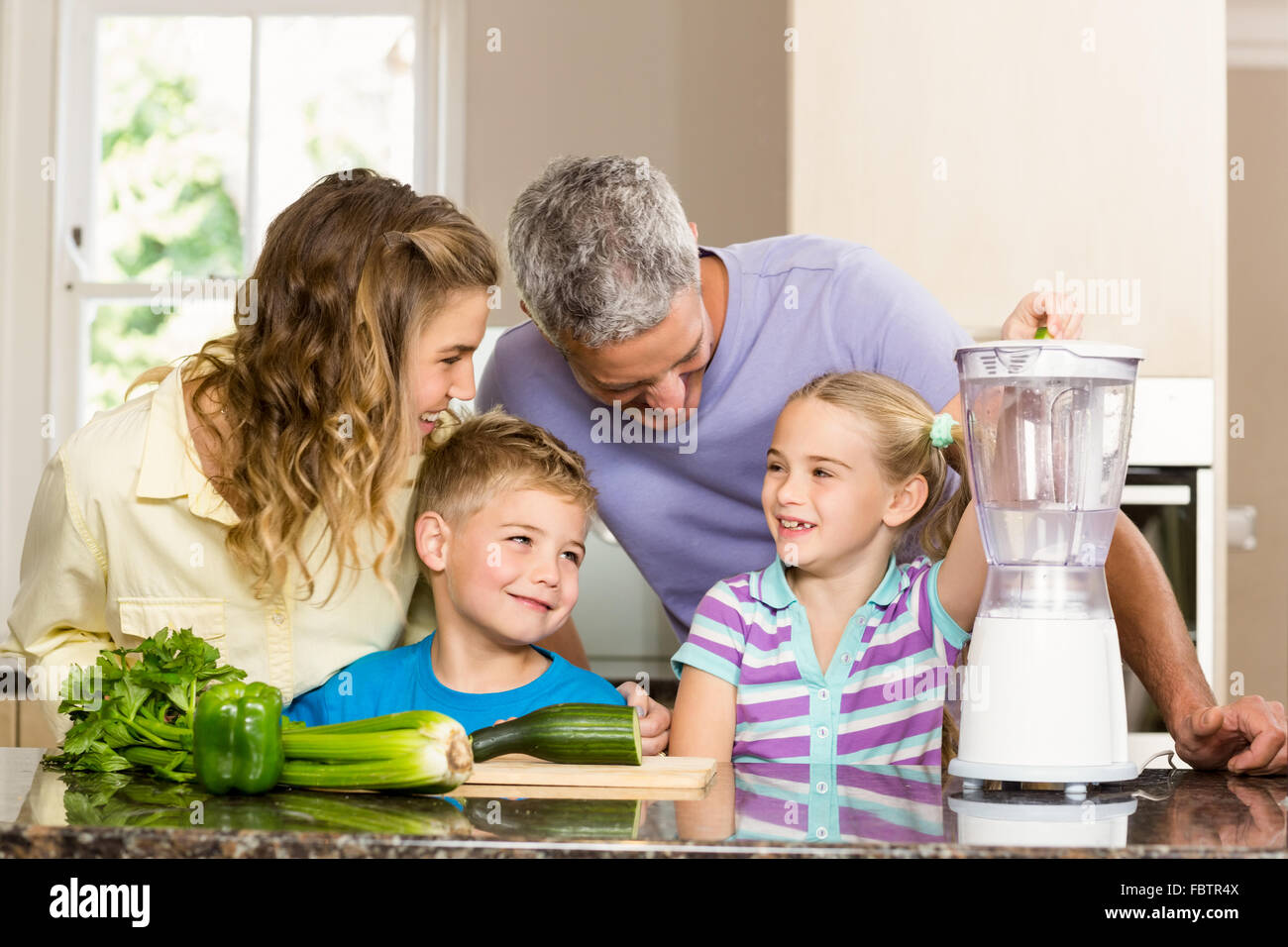 Happy family preparing healthy smoothie Stock Photo - Alamy