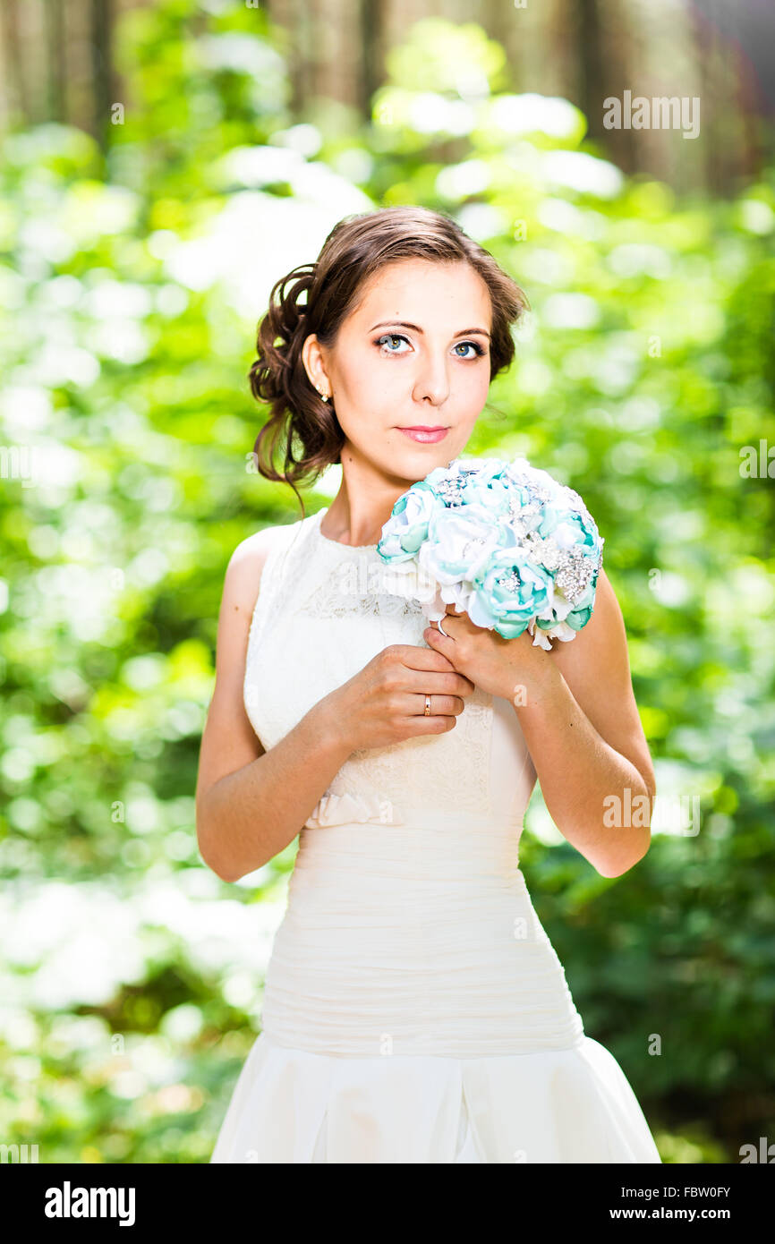 Young bride in wedding dress holding bouquet Stock Photo - Alamy