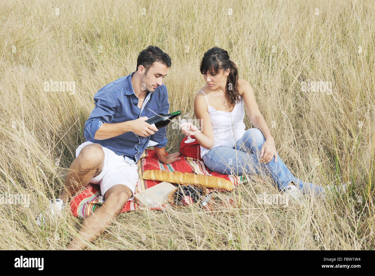 happy couple enjoying countryside picnic in long grass Stock Photo - Alamy