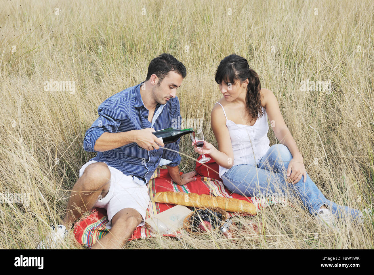 happy couple enjoying countryside picnic in long grass Stock Photo - Alamy