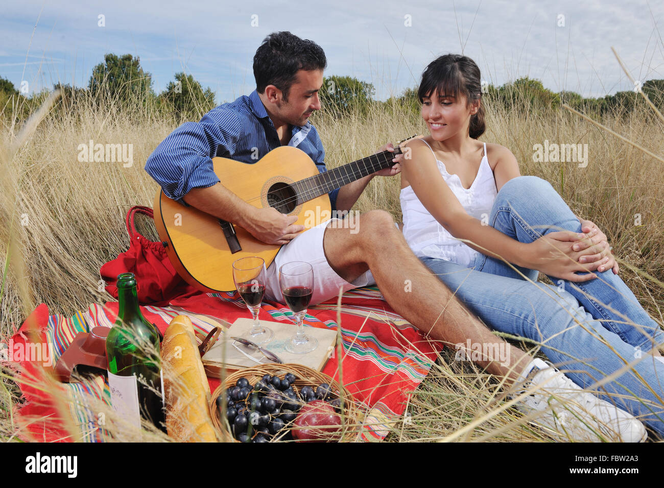 happy couple enjoying countryside picnic in long grass Stock Photo - Alamy