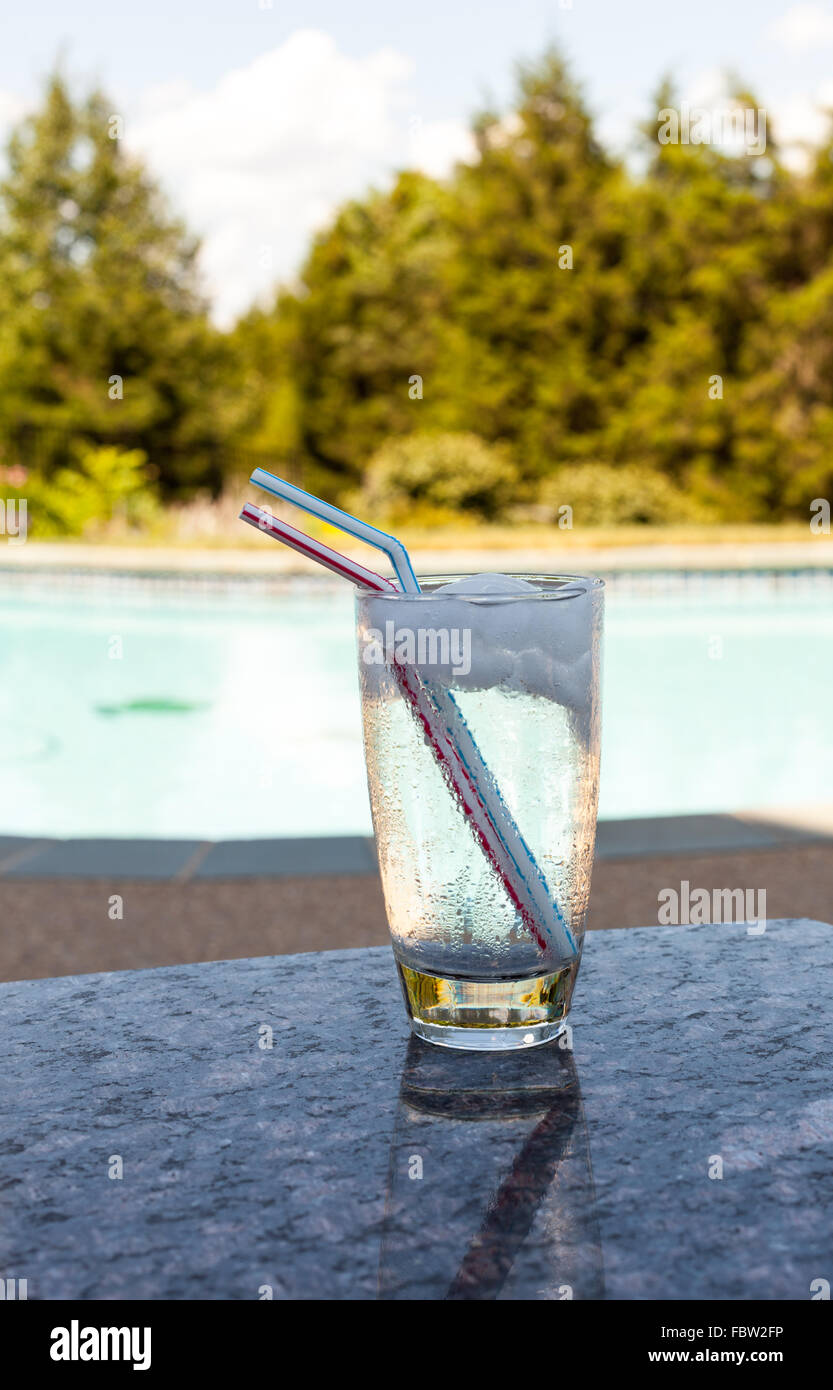 Glass of water with ice cubes on side of pool Stock Photo - Alamy