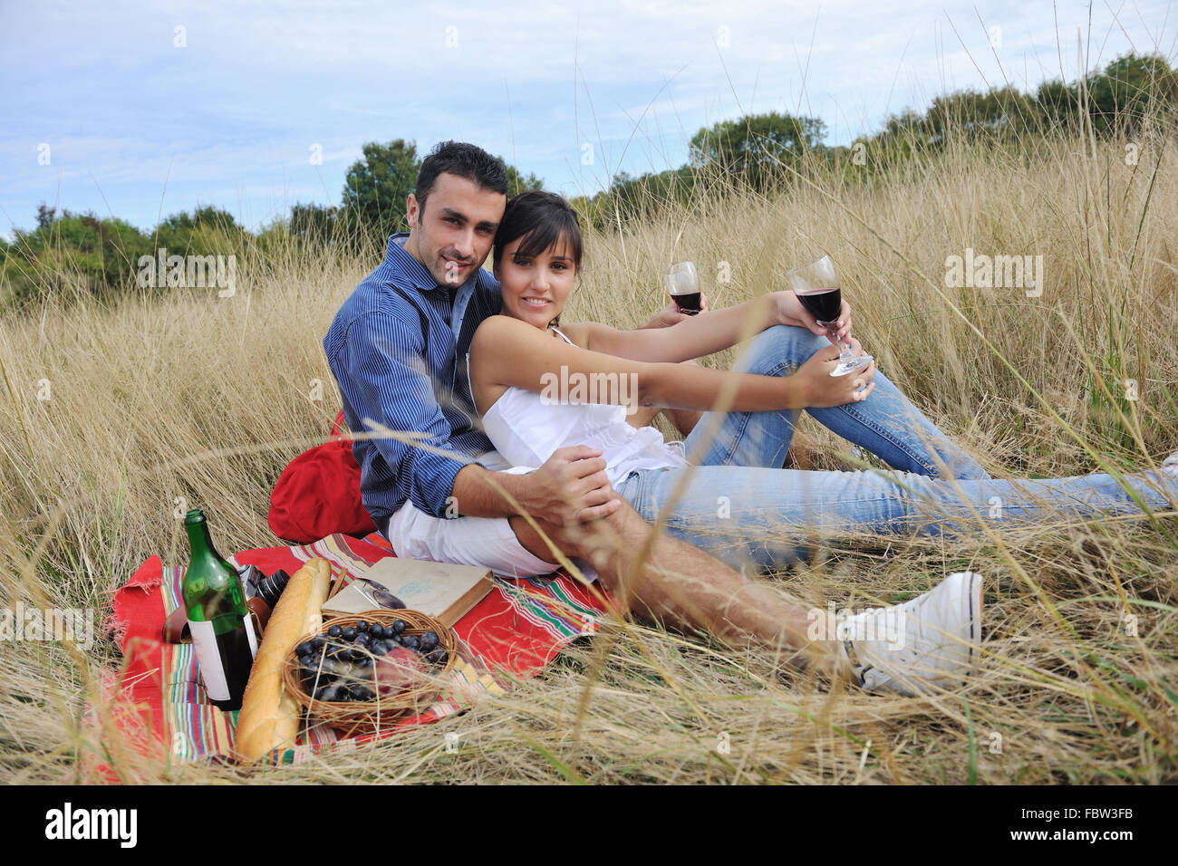 happy couple enjoying countryside picnic in long grass Stock Photo - Alamy