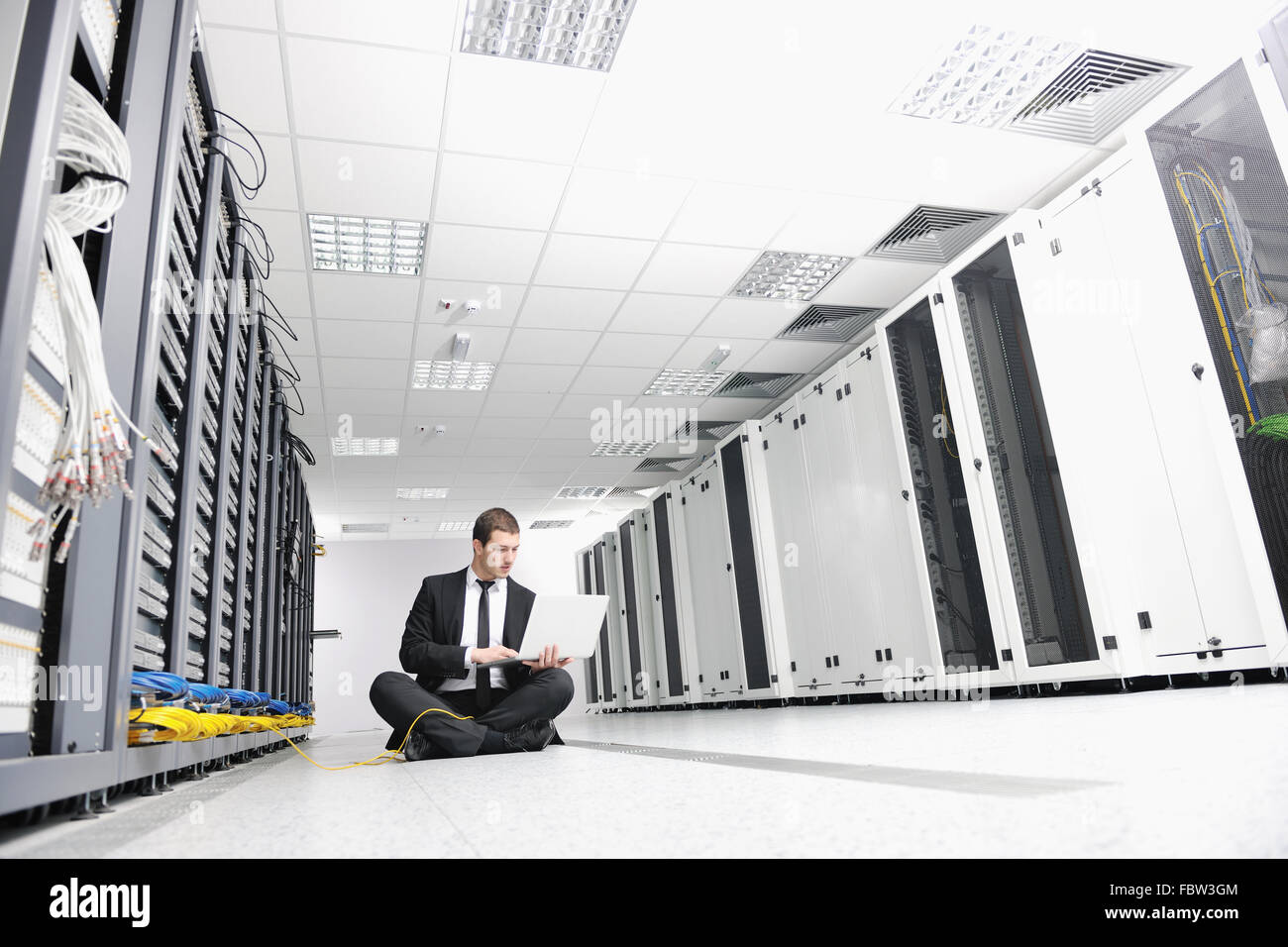 businessman with laptop in network server room Stock Photo - Alamy