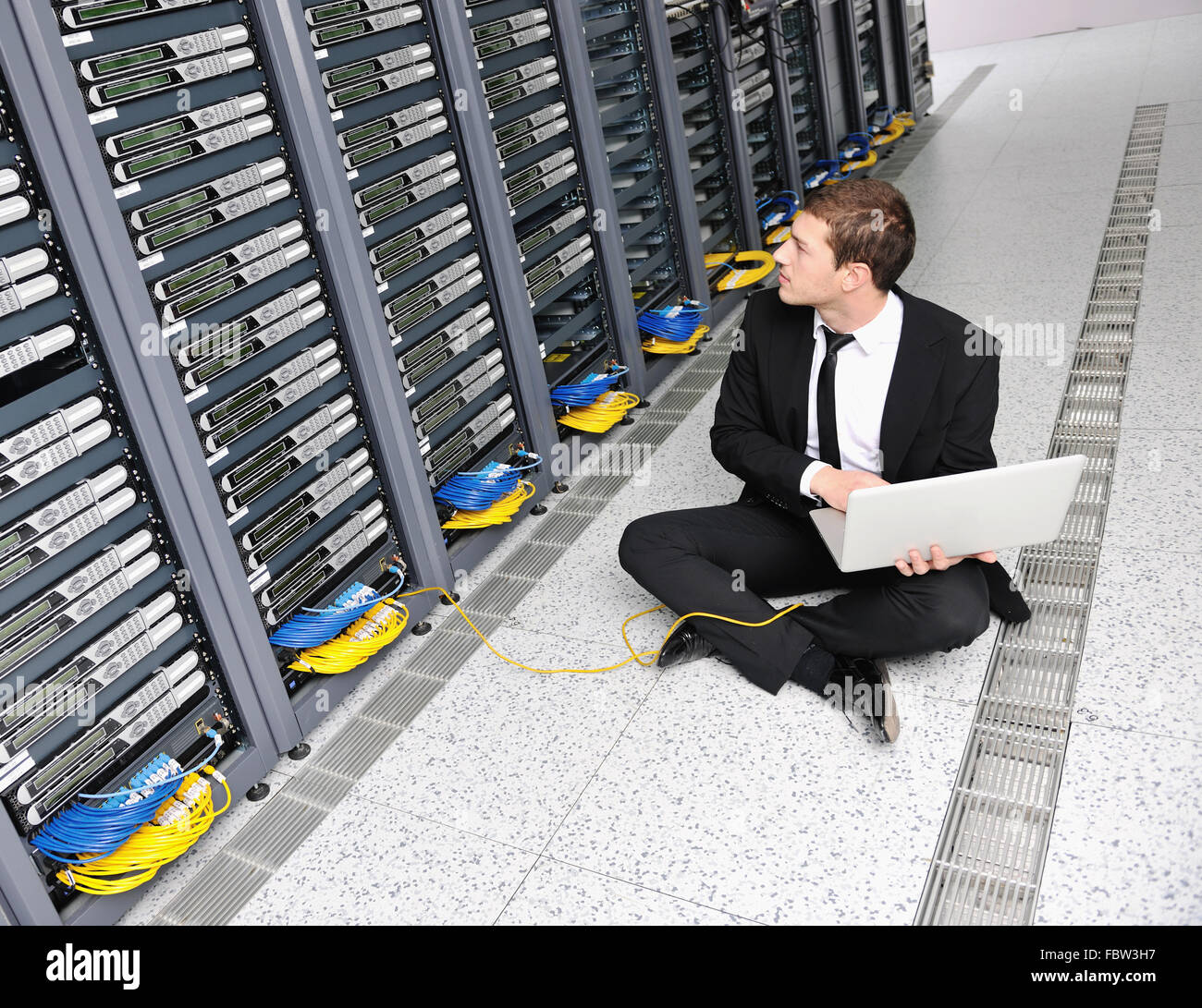businessman with laptop in network server room Stock Photo - Alamy