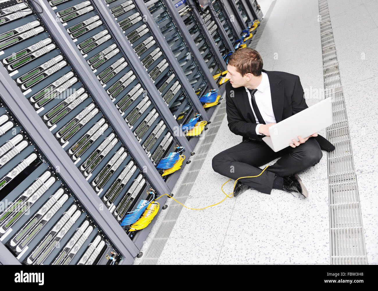 businessman with laptop in network server room Stock Photo - Alamy
