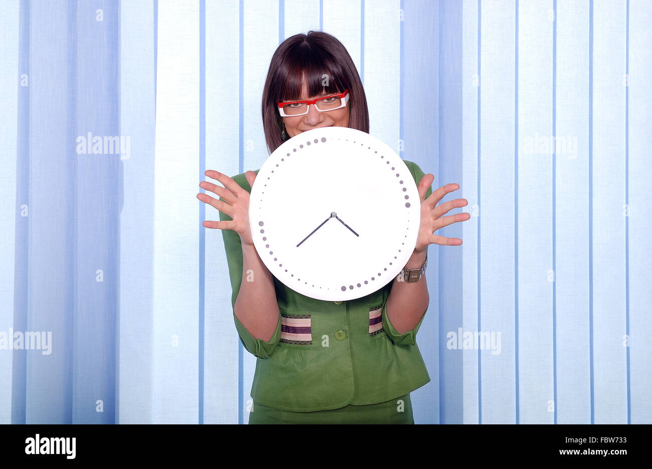 .a pretty business woman hiding behind a clock Stock Photo - Alamy