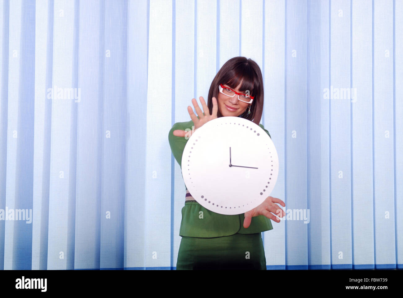 .a pretty business woman hiding behind a clock Stock Photo - Alamy