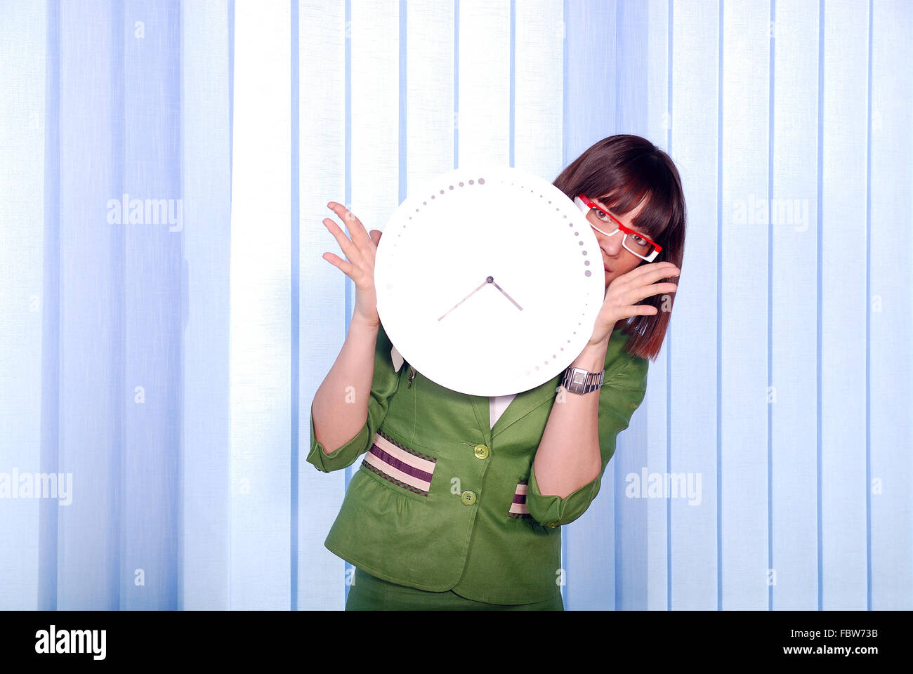 .a pretty business woman hiding behind a clock Stock Photo - Alamy