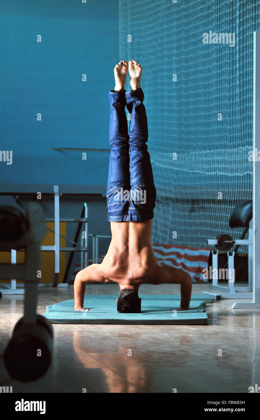 Young man performing handstand in fitness studio Stock Photo - Alamy