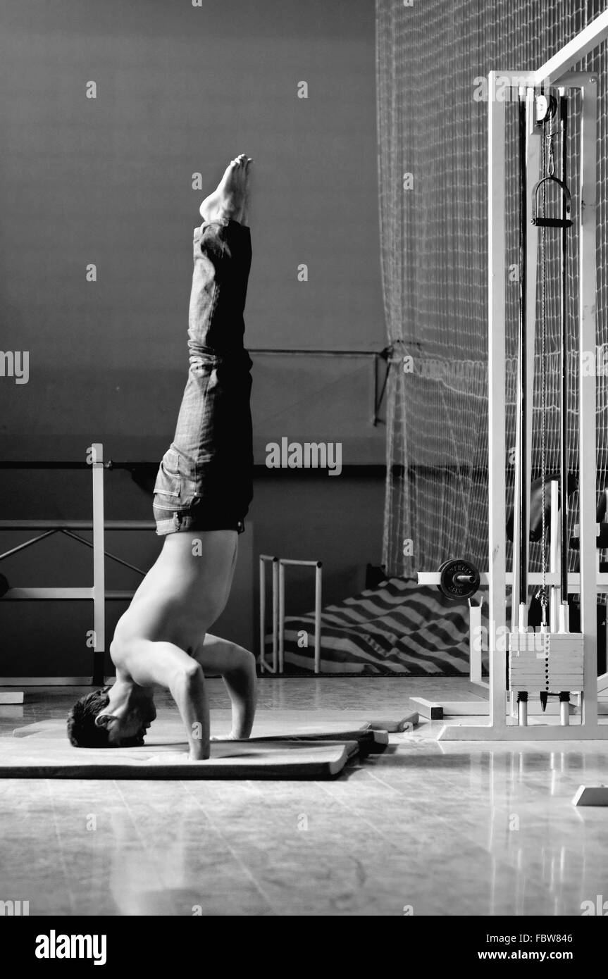 Young man performing handstand in fitness studio Stock Photo - Alamy