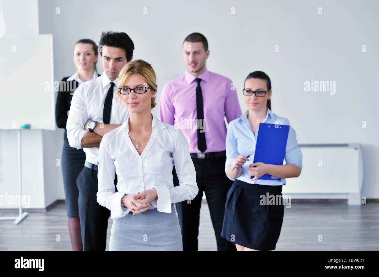 business woman standing with her staff in background Stock Photo - Alamy