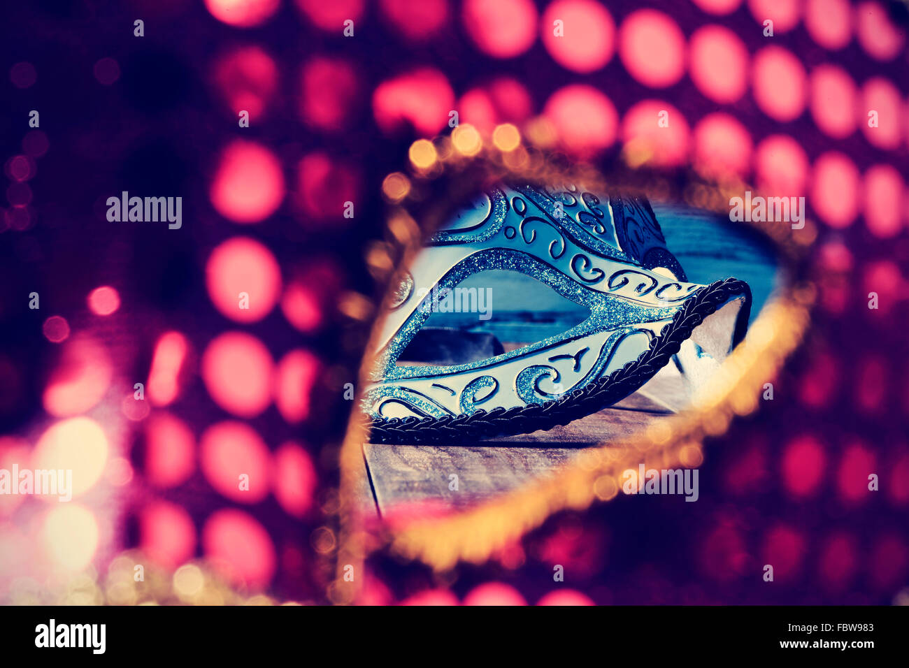 an elegant blue and black carnival mask seen through the eye hole of a ...