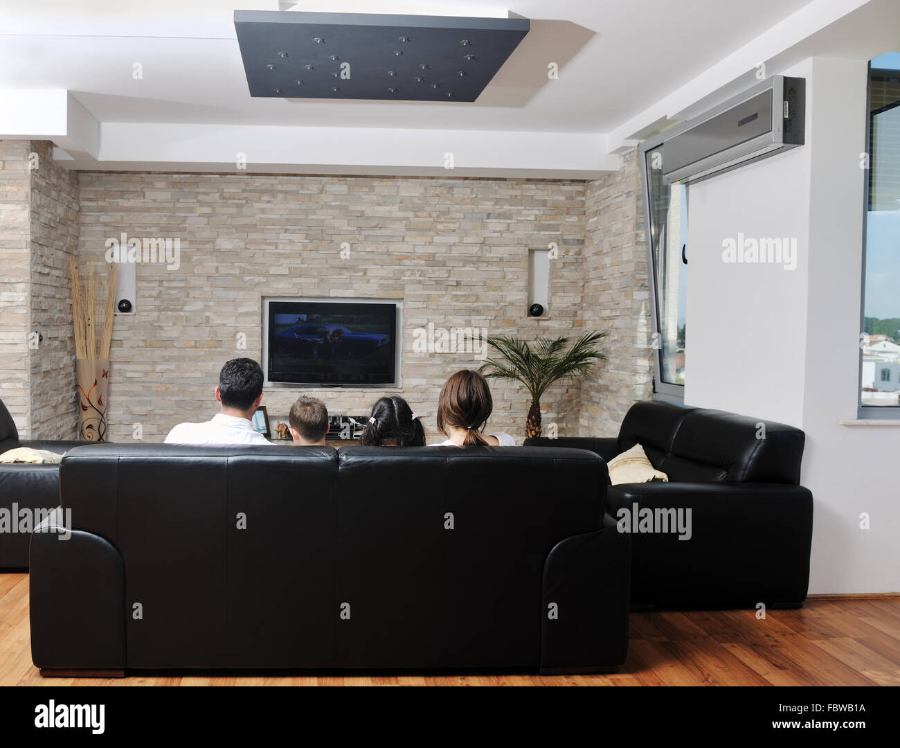 family wathching flat tv at modern home indoor Stock Photo - Alamy